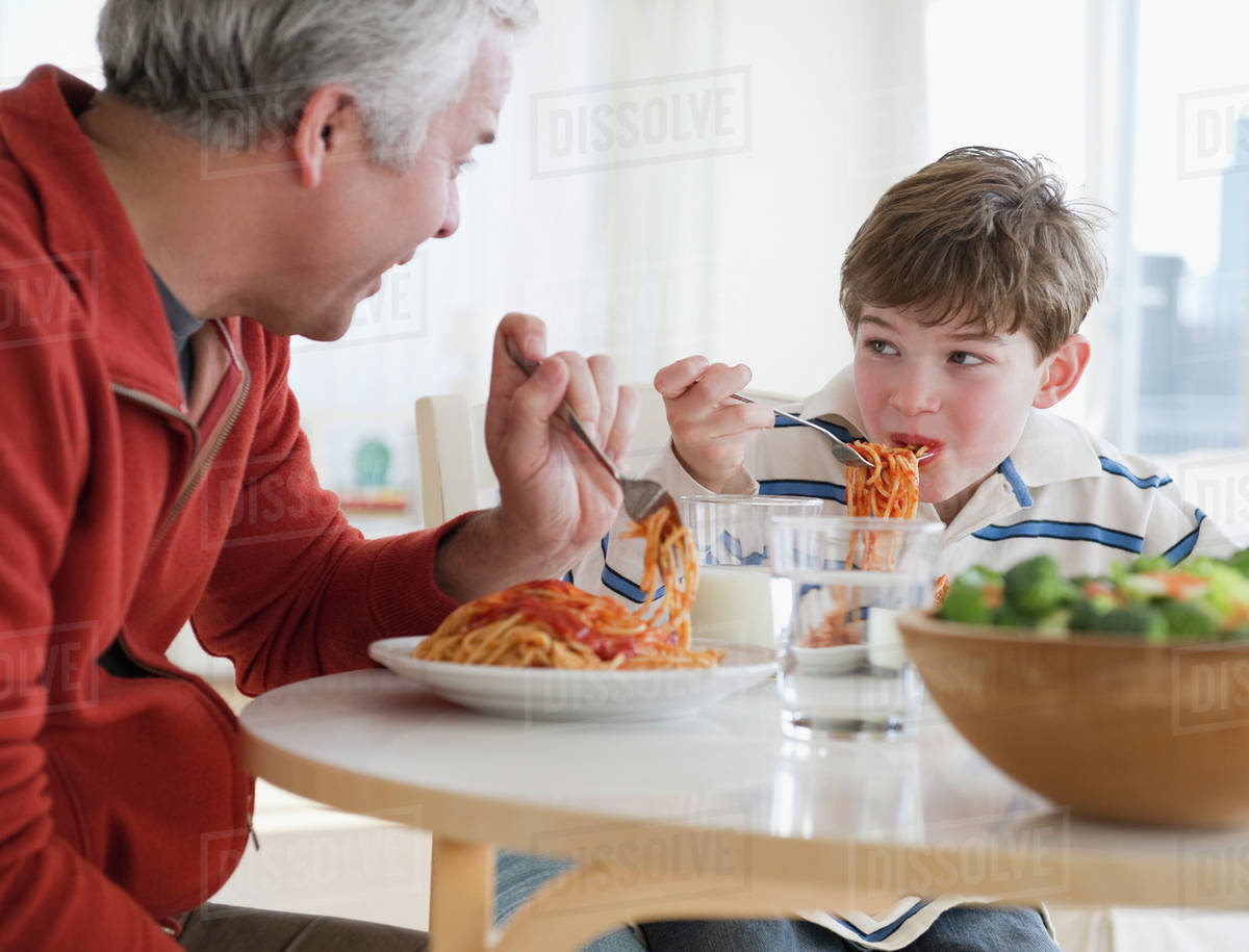 Father and son eating spaghetti - Royalty-free Stock Photo | Dissolve
