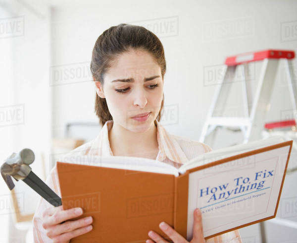Confused woman reading do it yourself book - Royalty-free Stock Photo ...