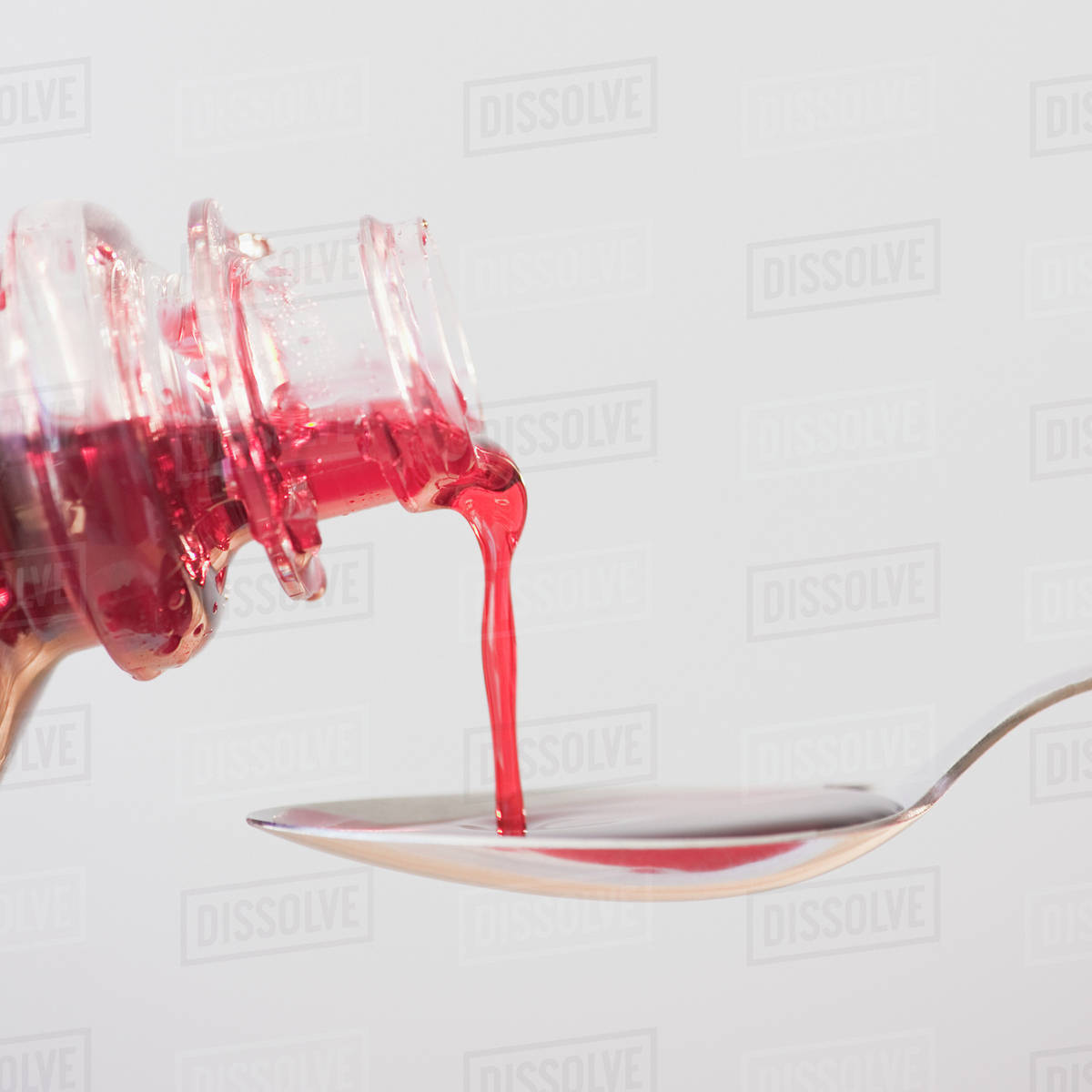 Cough syrup being poured onto spoon - Royalty-free Stock Photo | Dissolve