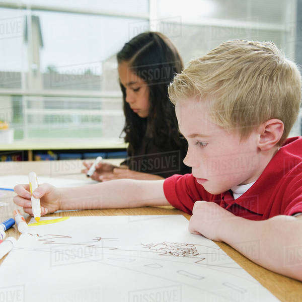 Elementary students drawing at their desks - Stock Photo - Dissolve
