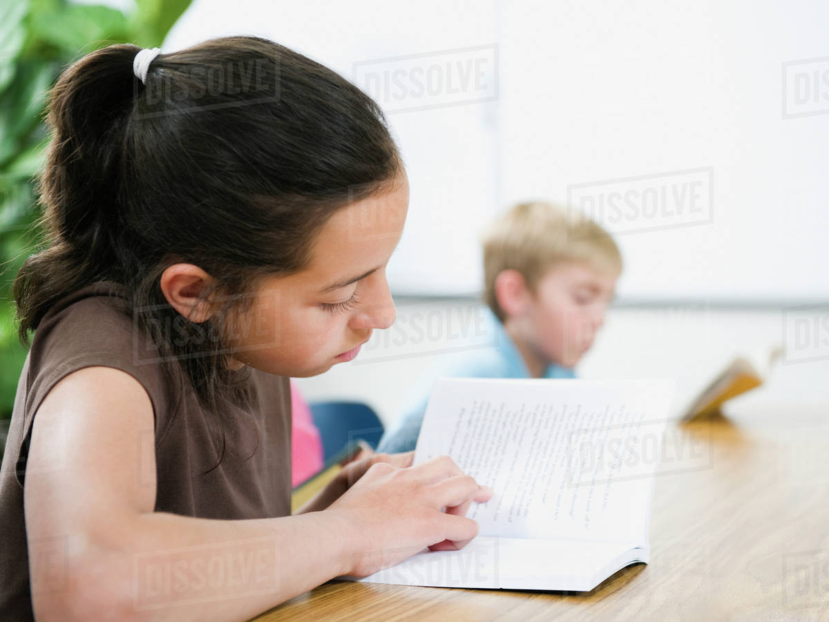 Elementary school students reading books at desk - Royalty-free Stock ...