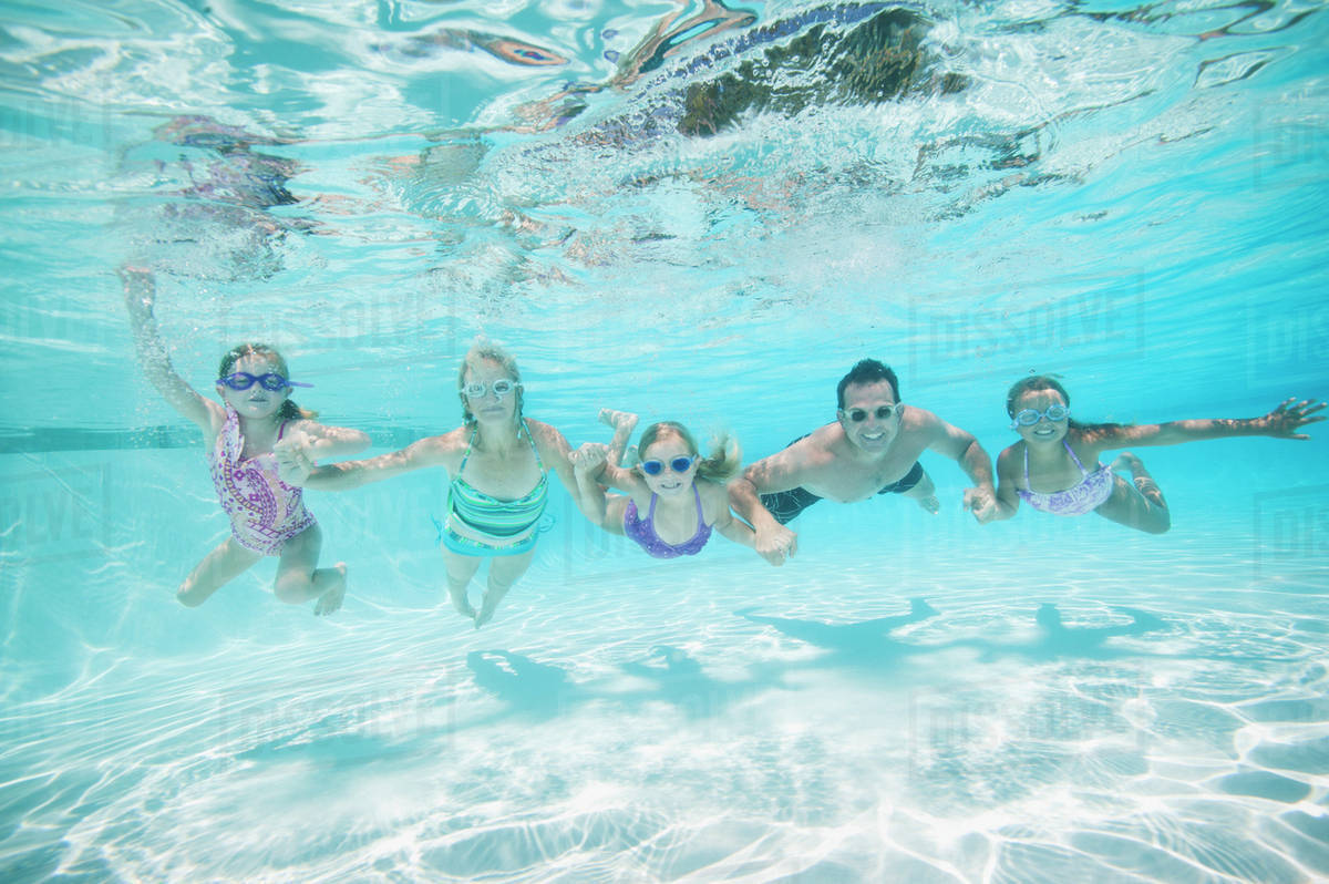 Family with three daughters (4-5,6-7,8-9) swimming underwater - Royalty ...