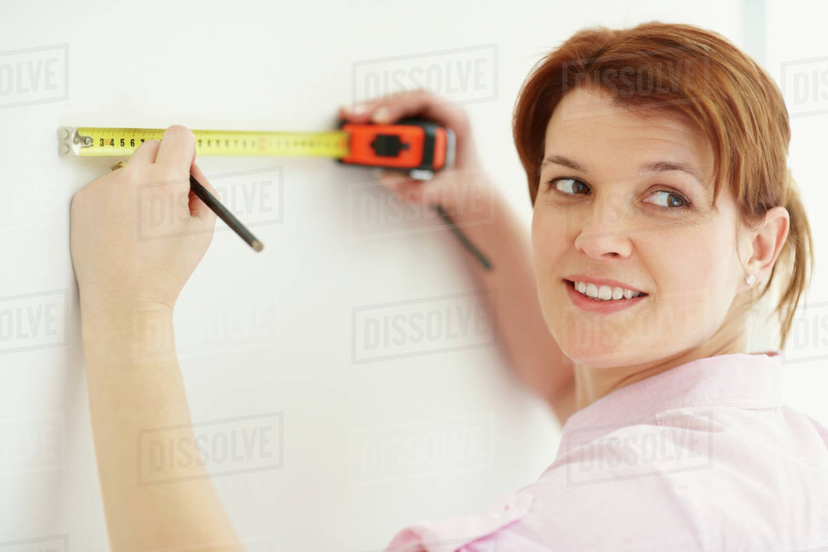 Woman using measuring tape - Royalty-free Stock Photo | Dissolve