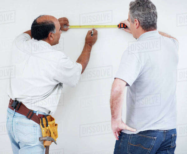 Men measuring wall - Royalty-free Stock Photo | Dissolve
