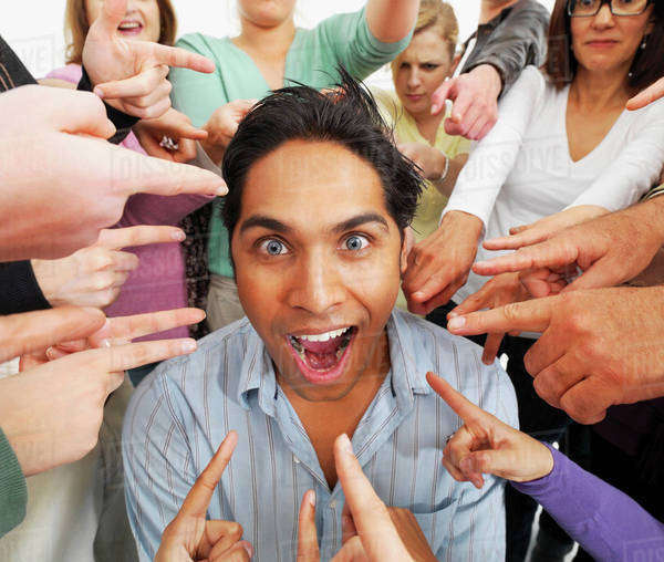 Group of people pointing at one person - Stock Photo - Dissolve