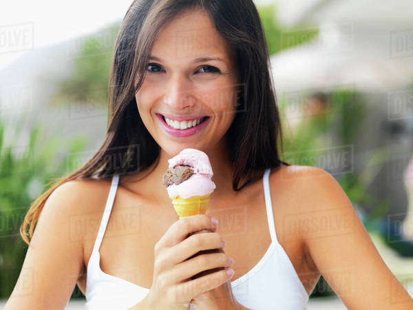 Woman eating ice cream cone - Royalty-free Stock Photo | Dissolve