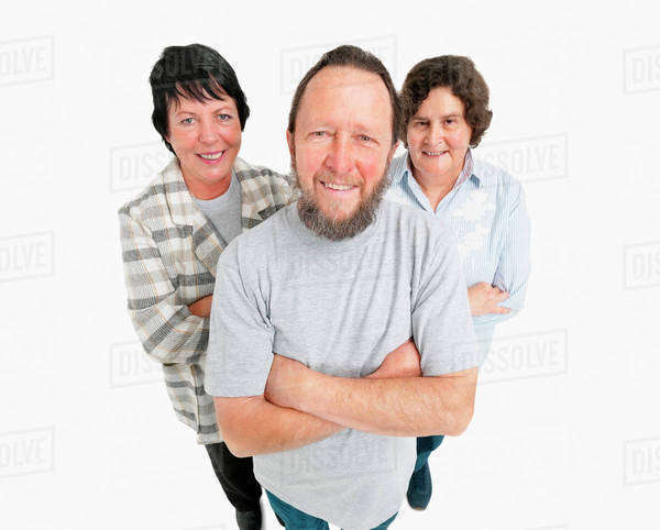 Three people standing with their arms crossed - Stock Photo - Dissolve