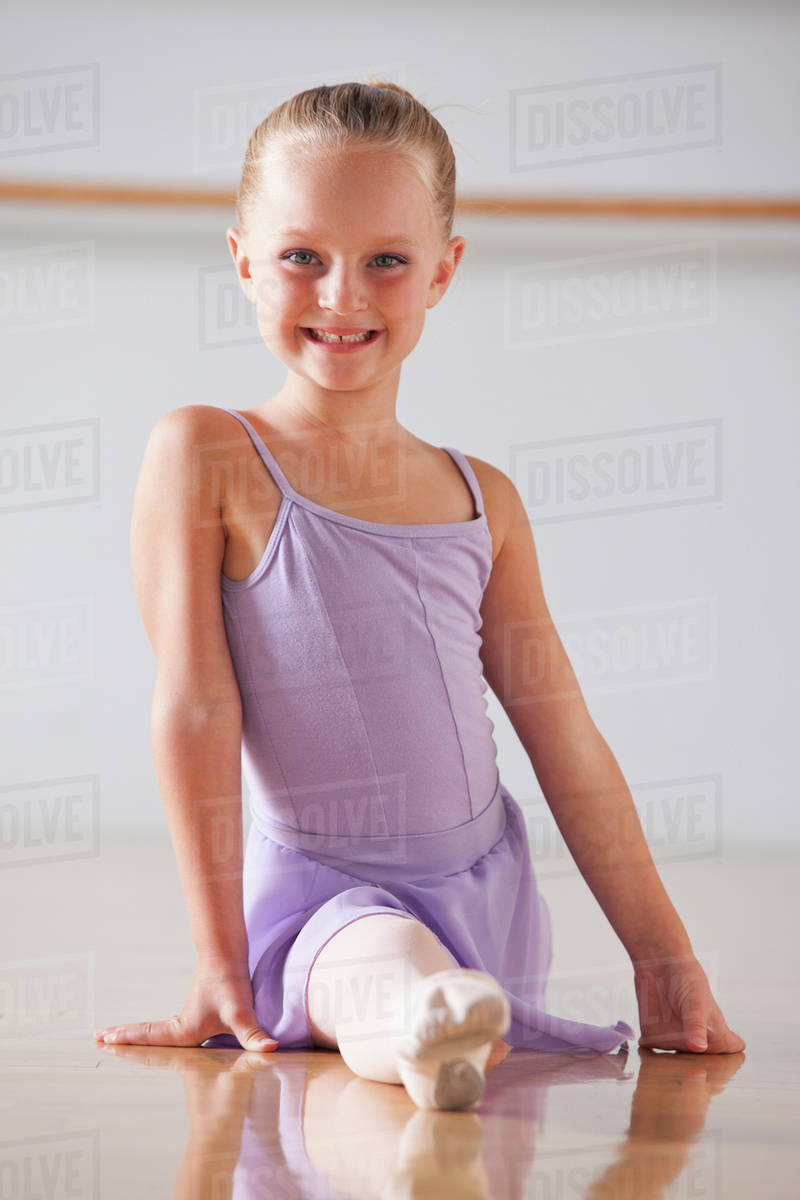 Portrait of ballet dancer (6-7) performing splits in dance studio ...