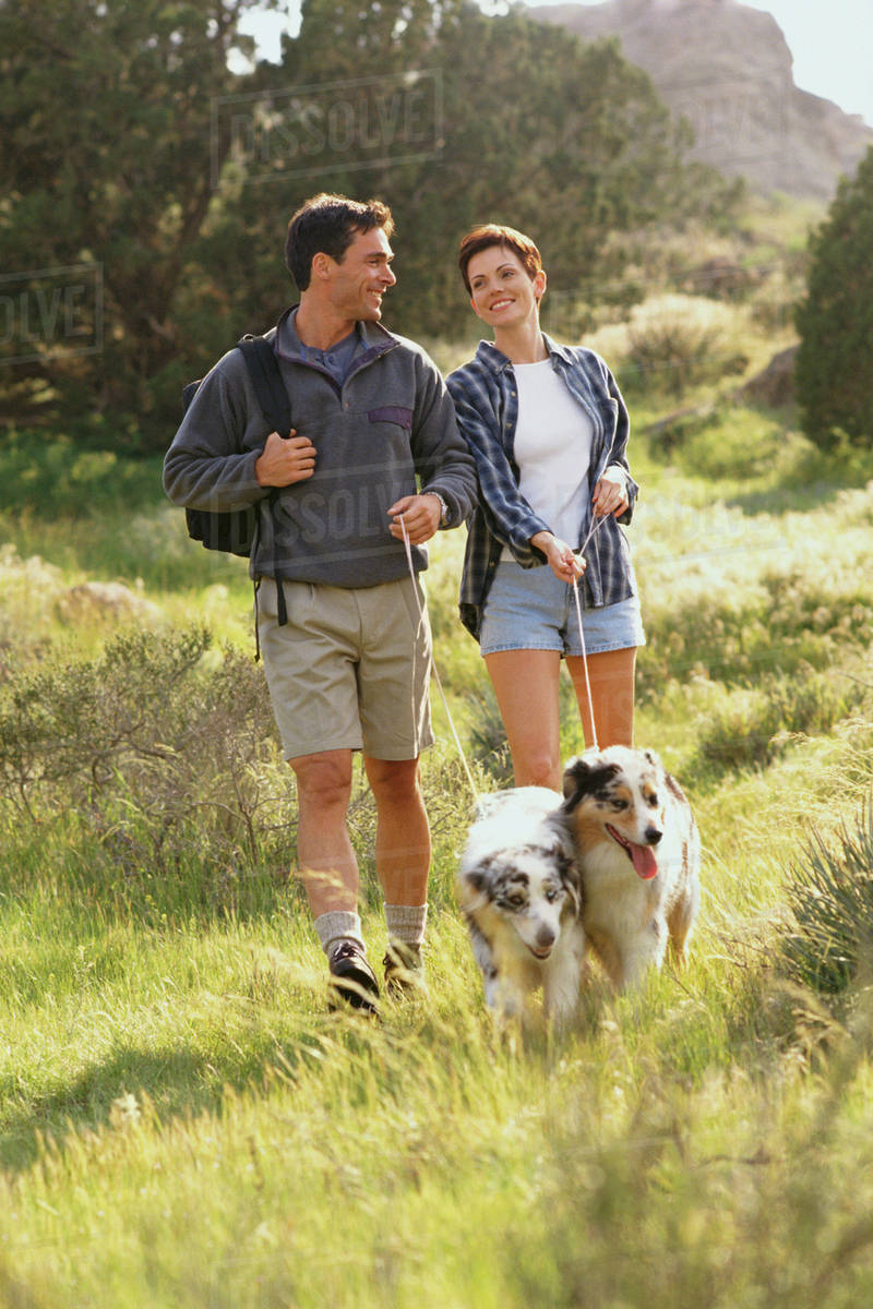 Couple walking their dogs in the countryside - Royalty-free Stock Photo ...