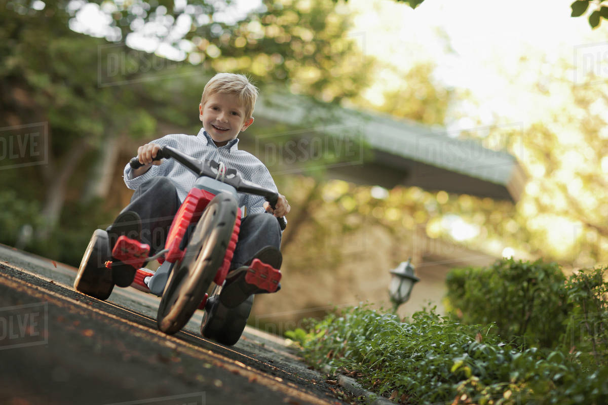 Portrait of boy (6-7) riding tricycle - Royalty-free Stock Photo | Dissolve