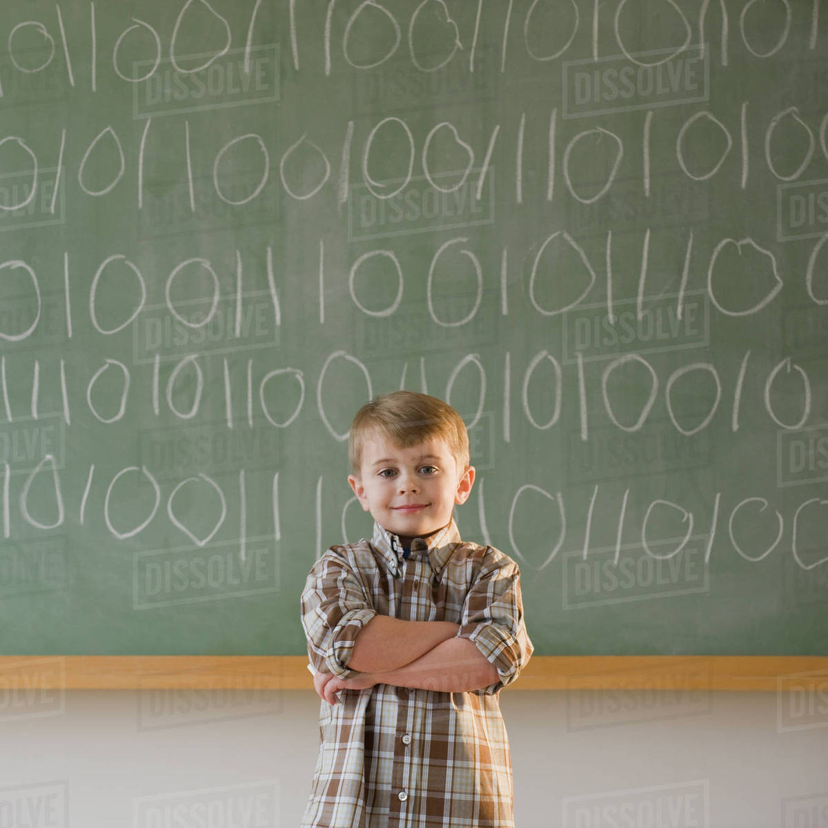 Boy writing binary code on blackboard - Stock Photo - Dissolve
