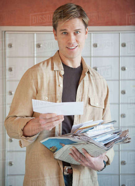 Man sorting stack of mail - Royalty-free Stock Photo | Dissolve