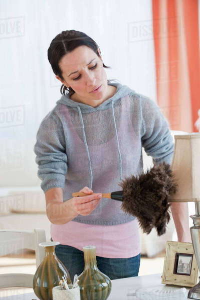 Woman dusting lamp - Stock Photo - Dissolve