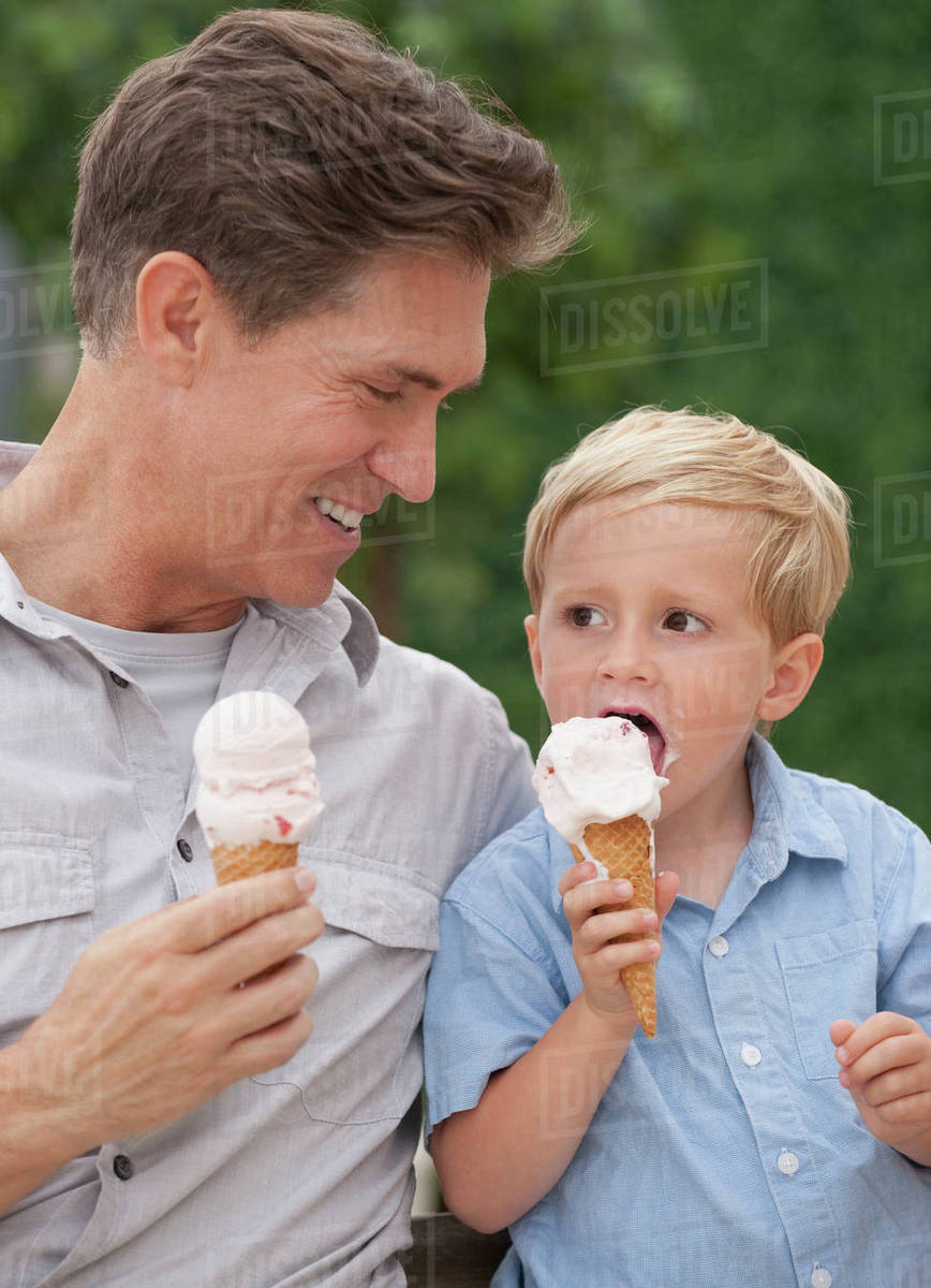 Father and child eating ice cream cones - Stock Photo - Dissolve