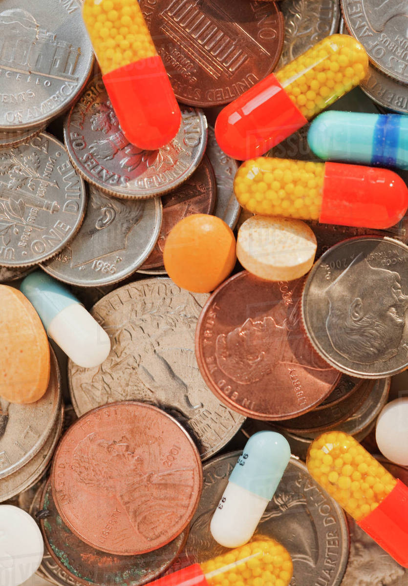 Assorted coins and pills - Stock Photo - Dissolve