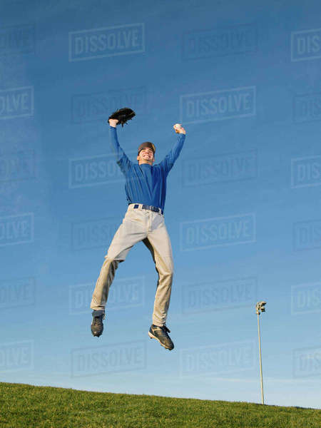 Baseball player jumping in air - Royalty-free Stock Photo | Dissolve