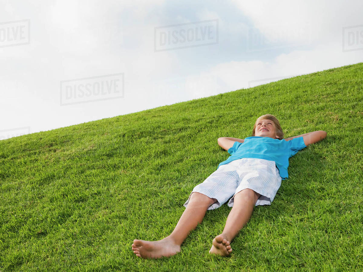 Boy resting on grass - Royalty-free Stock Photo | Dissolve