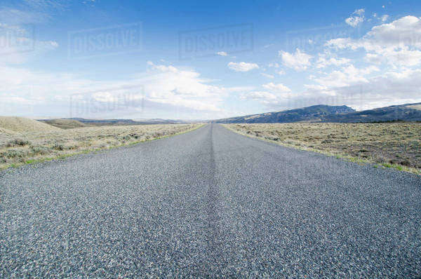 Road going through desolate landscape - Stock Photo - Dissolve