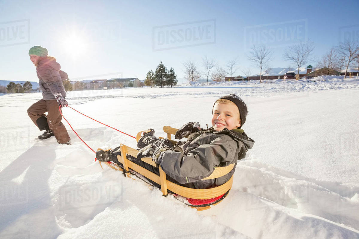 Children (8-9) playing with sled in snow - Royalty-free Stock Photo ...