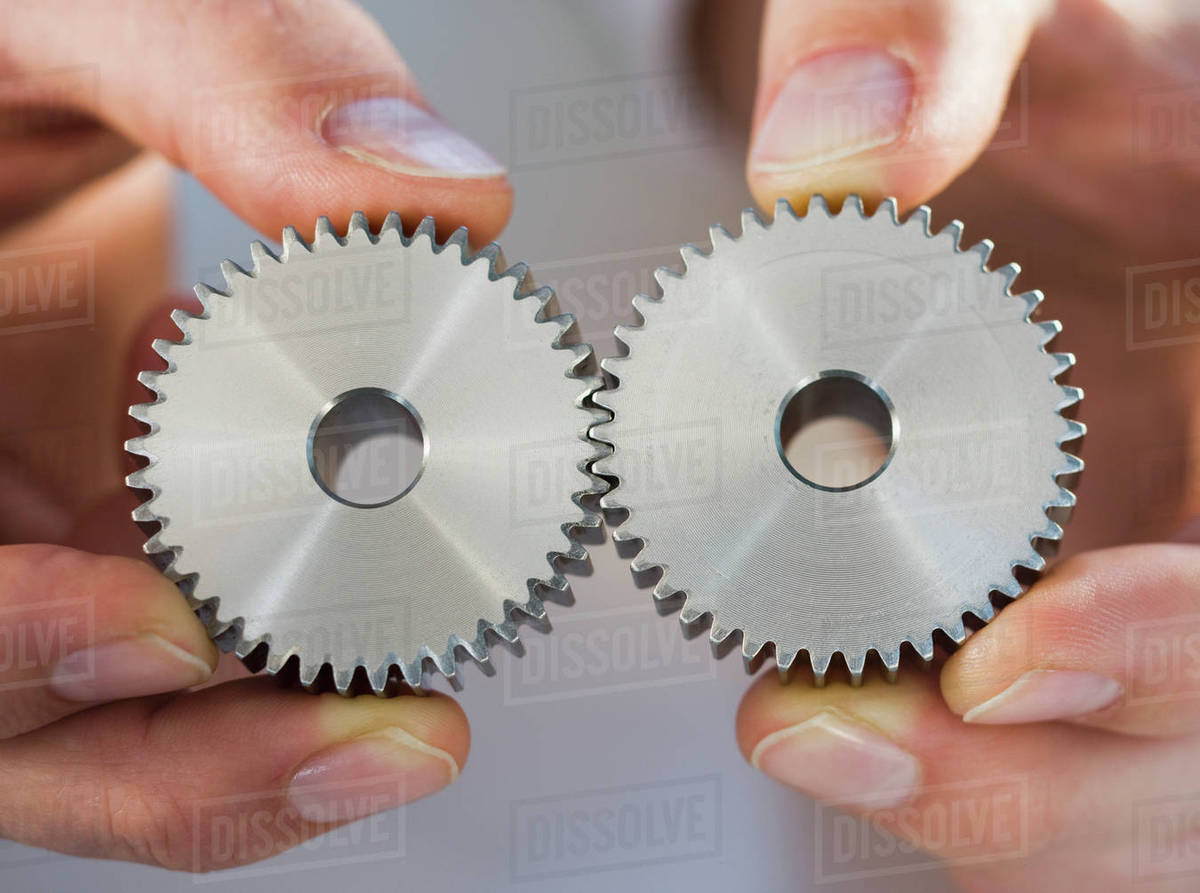 Man holding cog wheels - Stock Photo - Dissolve