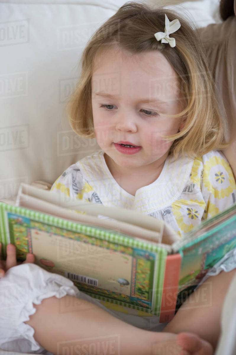 Young girl looking at book - Royalty-free Stock Photo | Dissolve