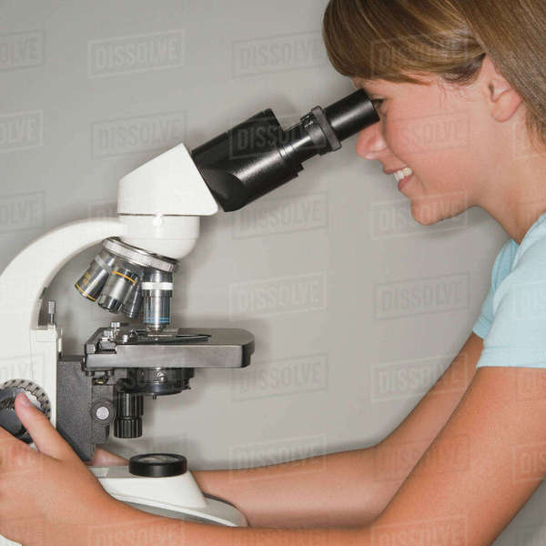 Girl using microscope - Stock Photo - Dissolve