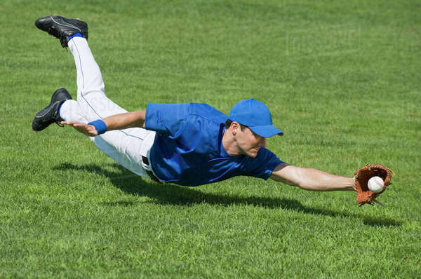 Baseball player diving to catch baseball - Royalty-free Stock Photo ...