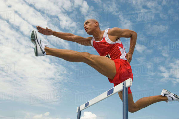 Runner jumping over hurdle - Royalty-free Stock Photo | Dissolve