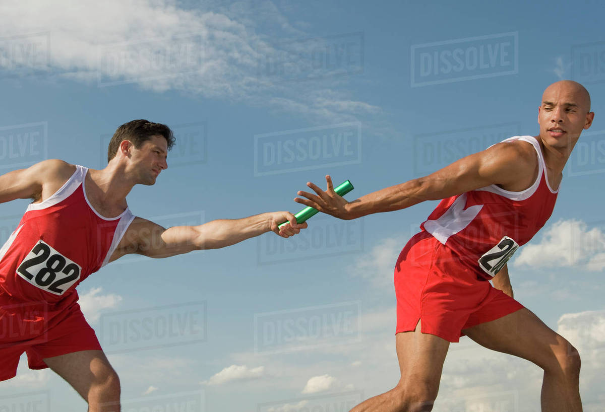 Runner passing baton to teammate - Royalty-free Stock Photo | Dissolve