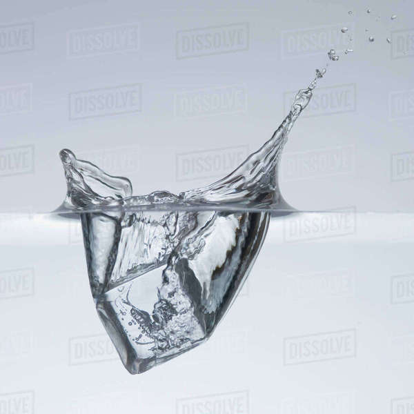Ice cube splashing in water - Stock Photo - Dissolve