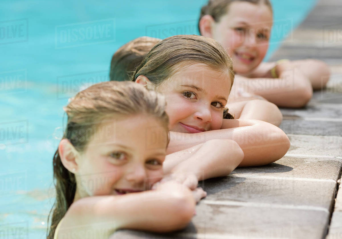 Girls in a row leaning on edge of swimming pool - Royalty-free Stock ...