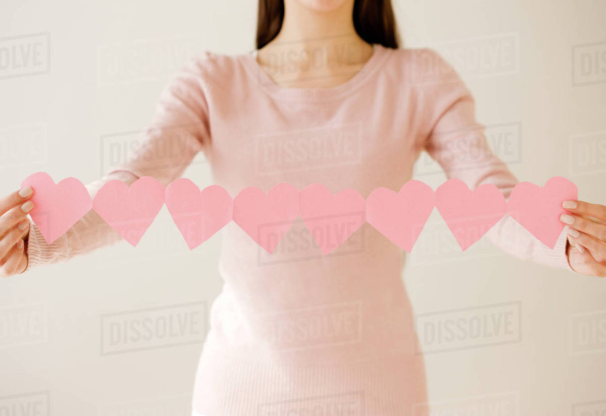 Woman holding string of cut out hearts - Royalty-free Stock Photo ...