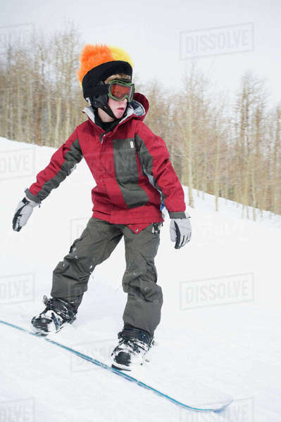 Boy snowboarding downhill - Stock Photo - Dissolve