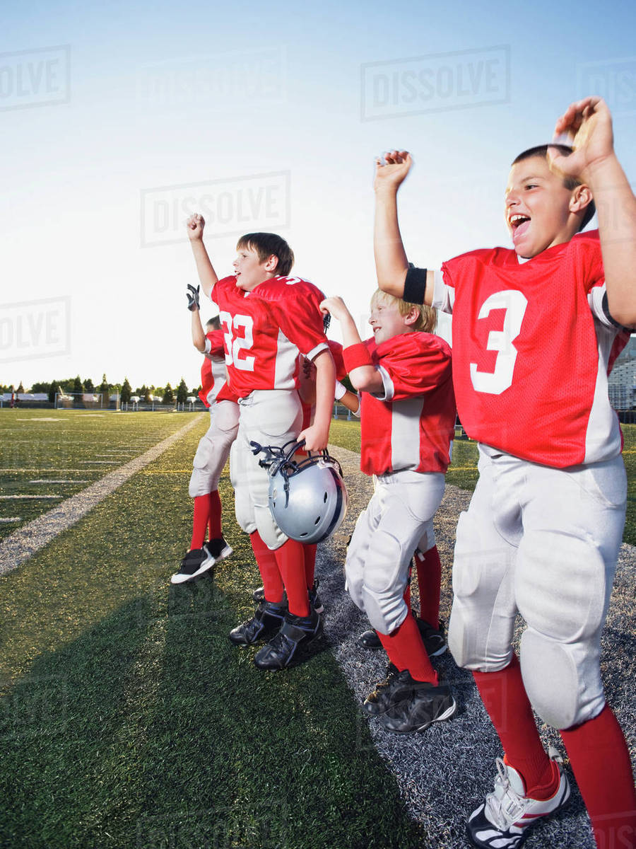 Football players cheering on sideline - Royalty-free Stock Photo | Dissolve