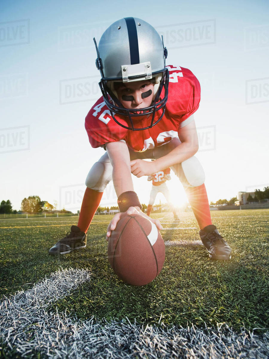 Football center ready to snap football - Stock Photo - Dissolve