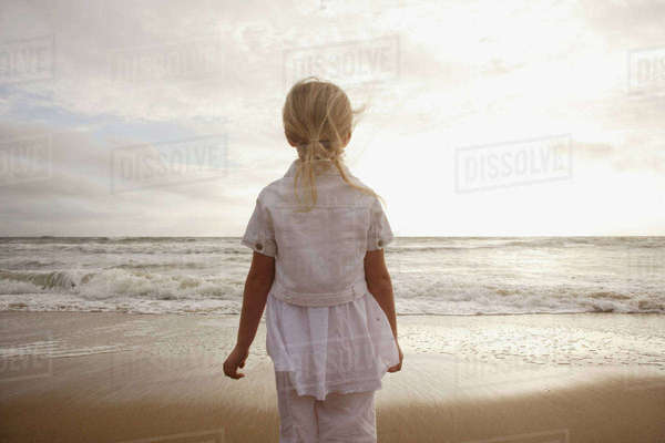 Girl looking out at ocean - Stock Photo - Dissolve