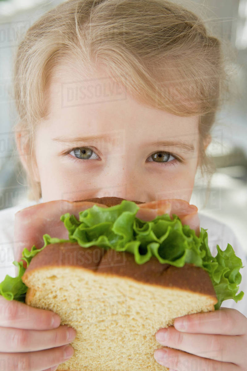 Girl eating sandwich - Stock Photo - Dissolve