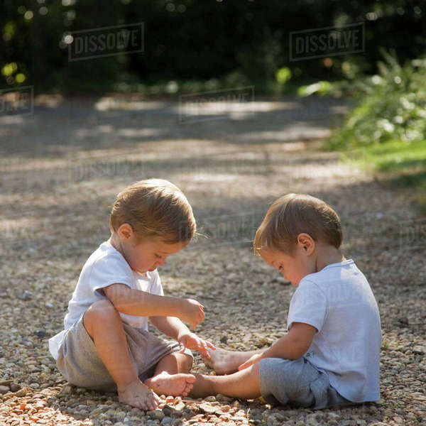 Toddler boys playing with pebbles - Royalty-free Stock Photo | Dissolve