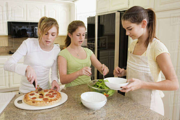 Teenaged girls serving food - Royalty-free Stock Photo | Dissolve