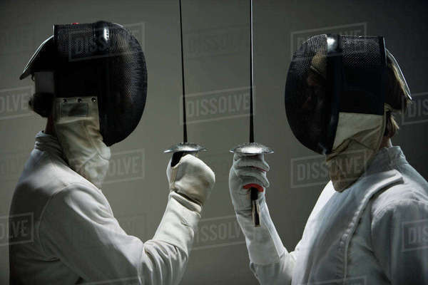 Fencers in masks facing off with fencing foils - Stock Photo - Dissolve