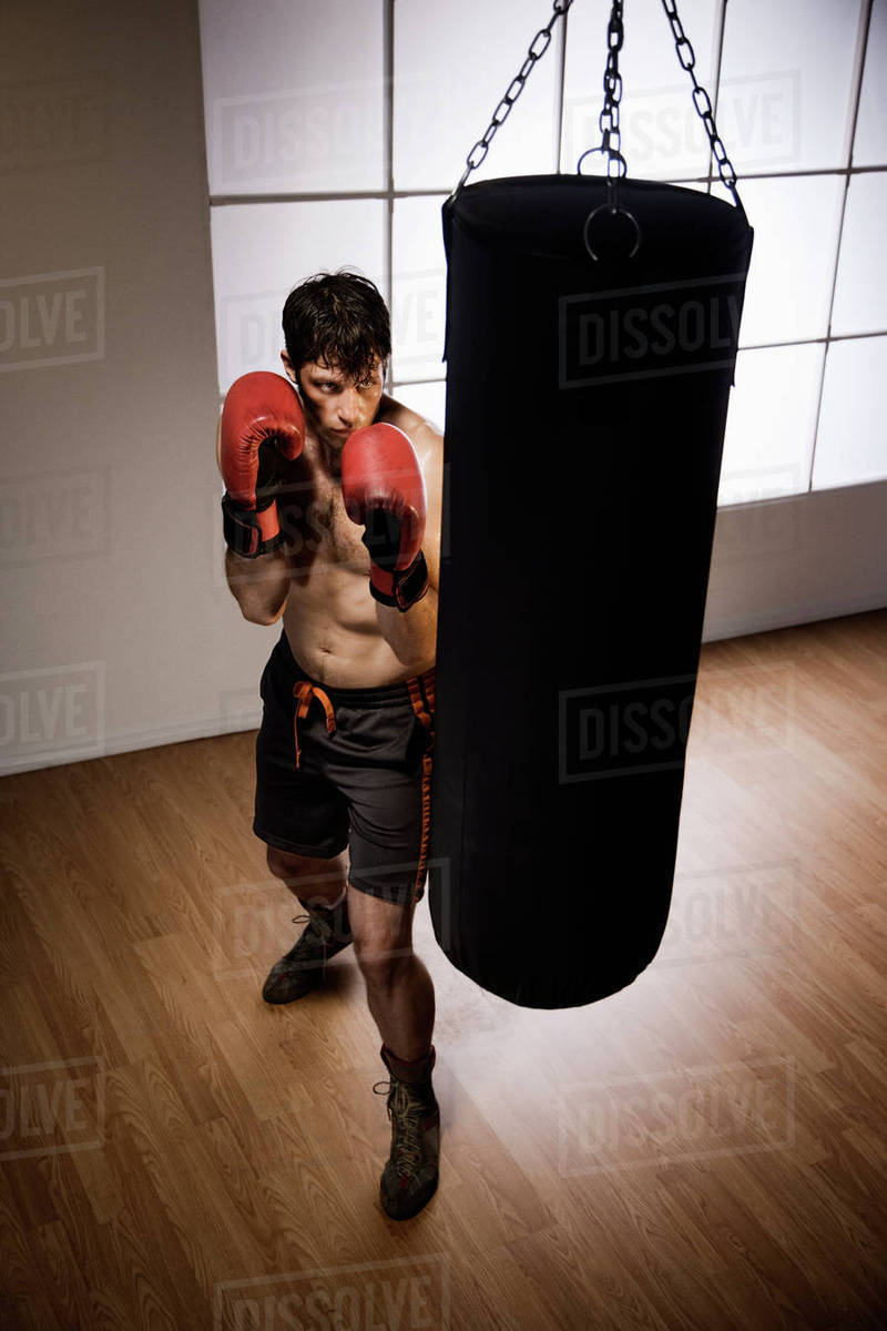 Boxer training with punching bag - Stock Photo - Dissolve