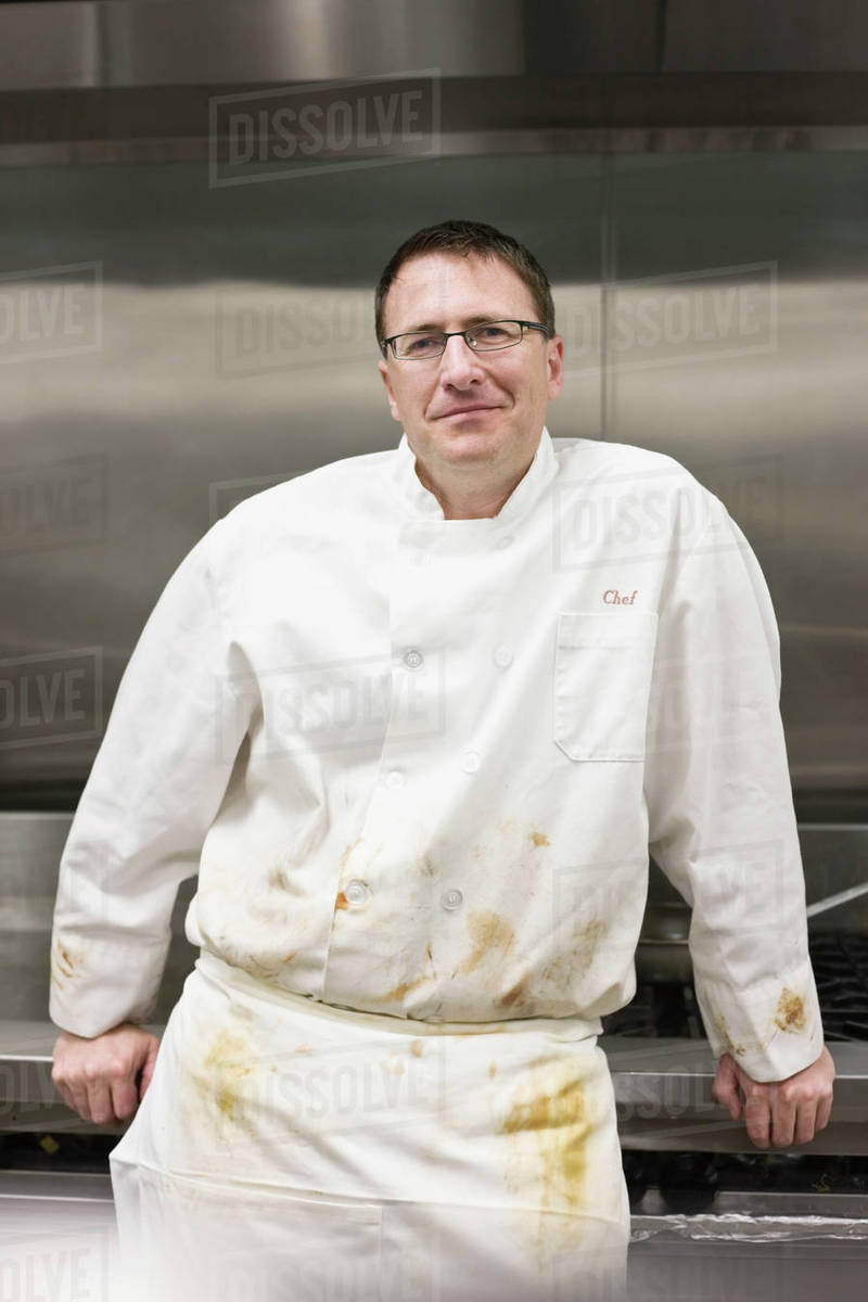 Dirty chef leaning against stove - Royalty-free Stock Photo | Dissolve