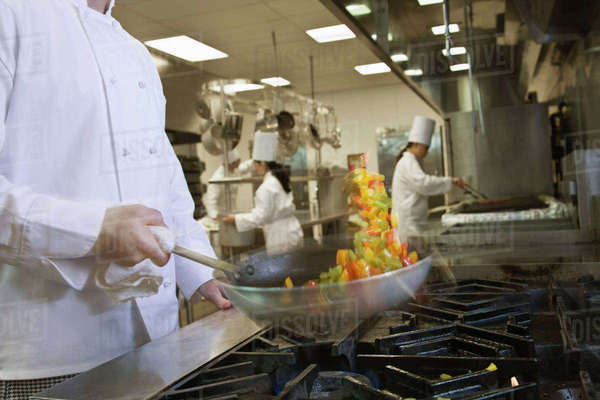 Chef tossing food in skillet - Royalty-free Stock Photo | Dissolve