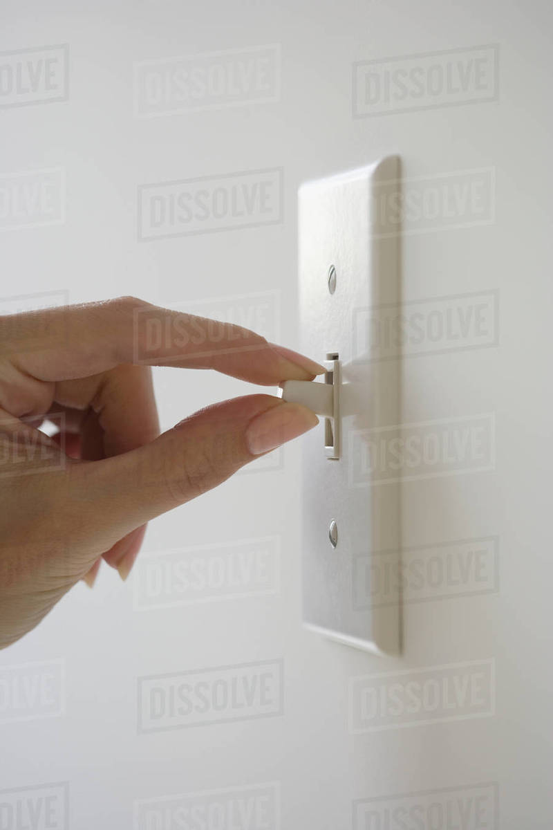 Close up of woman turning light switch - Royalty-free Stock Photo ...