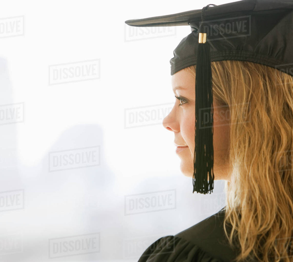 Woman wearing graduation cap and gown - Stock Photo - Dissolve