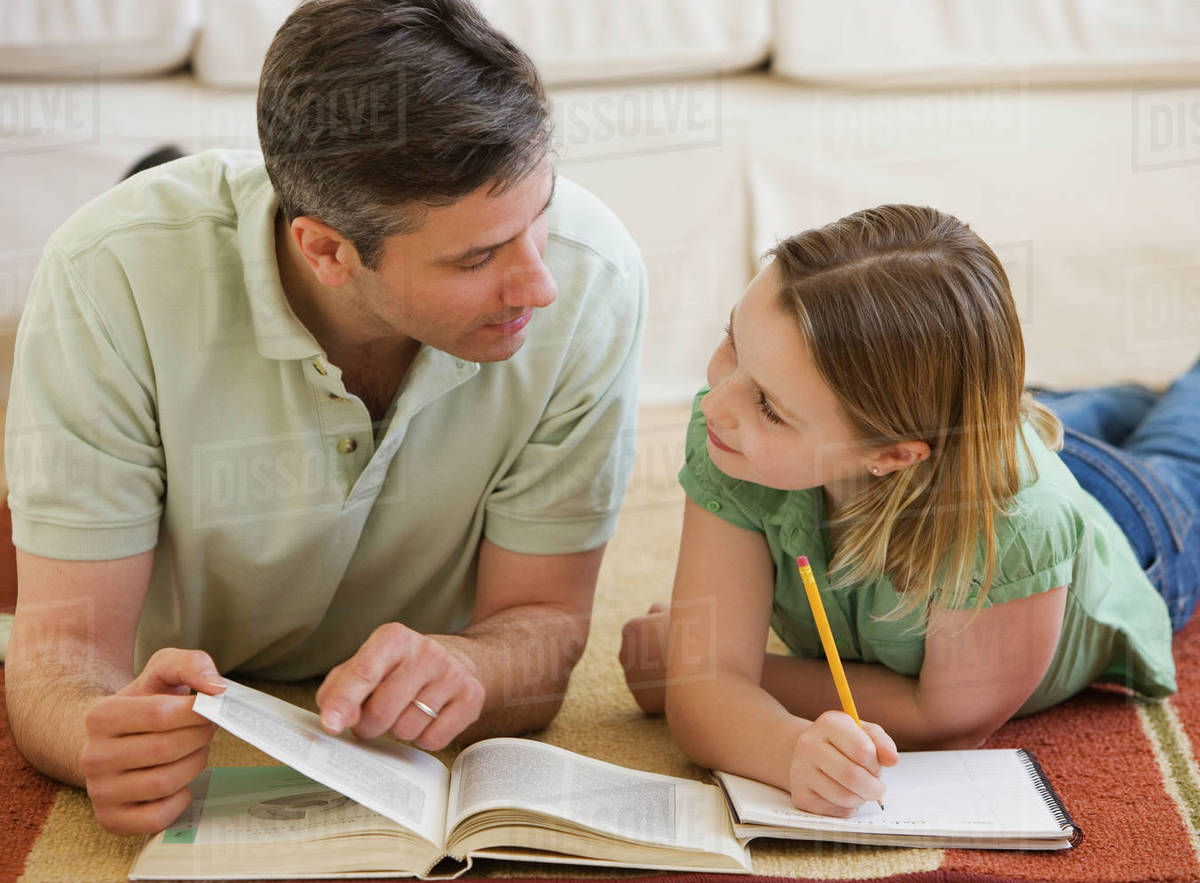 Father helping daughter with homework - Stock Photo - Dissolve