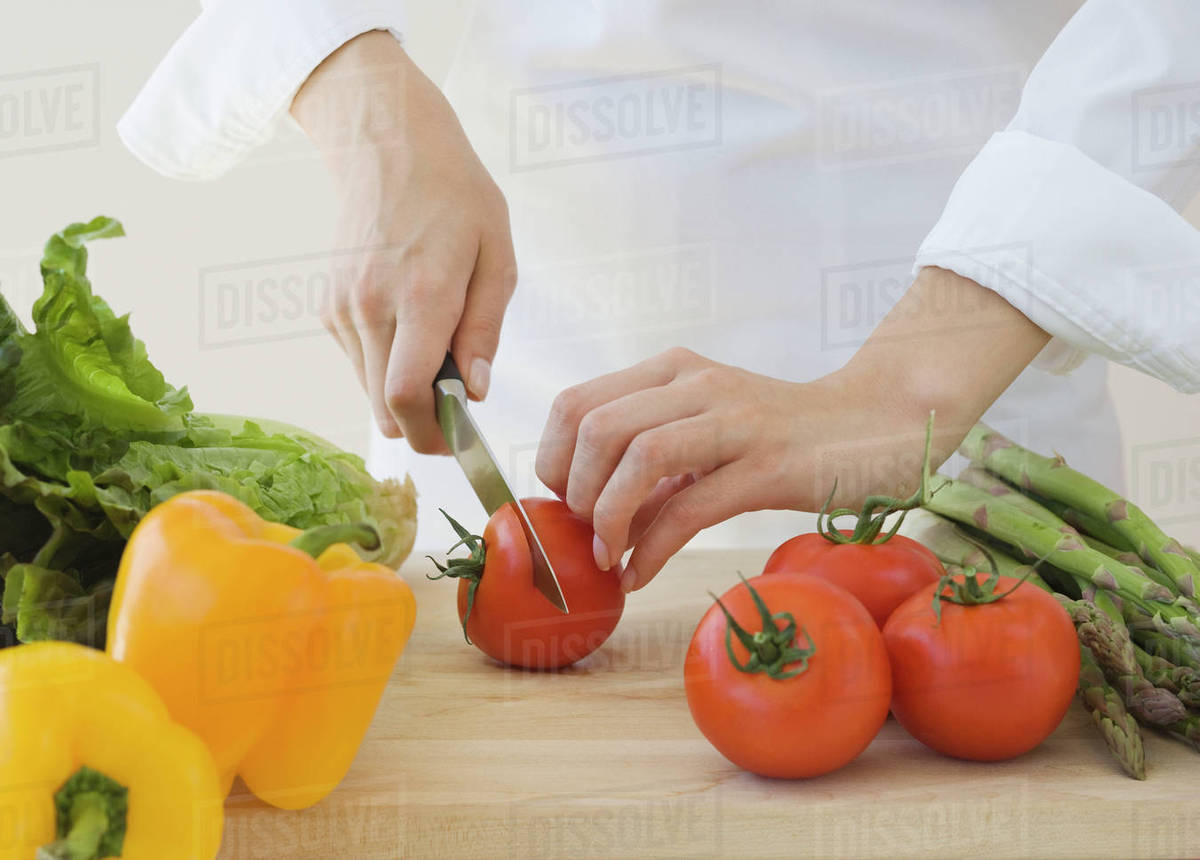 Woman chopping vegetables - Stock Photo - Dissolve