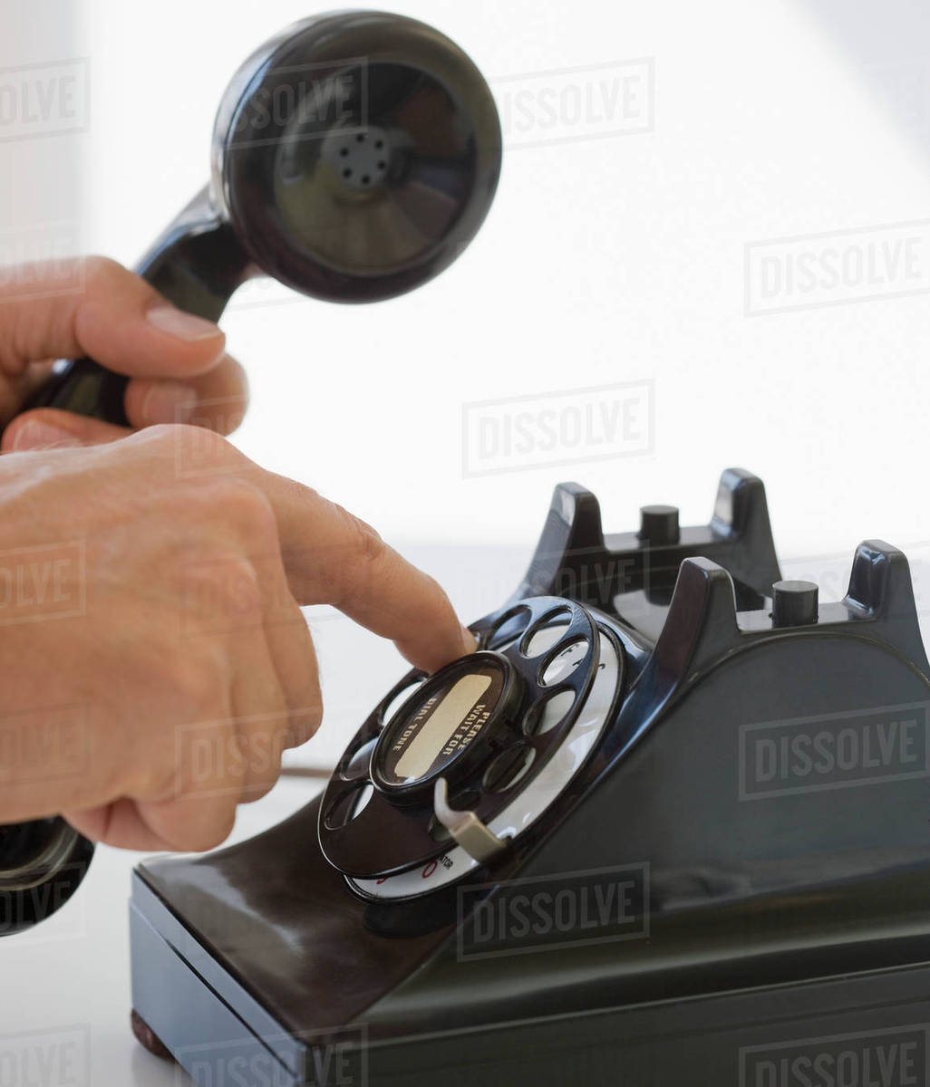 Man dialing rotary telephone - Stock Photo - Dissolve