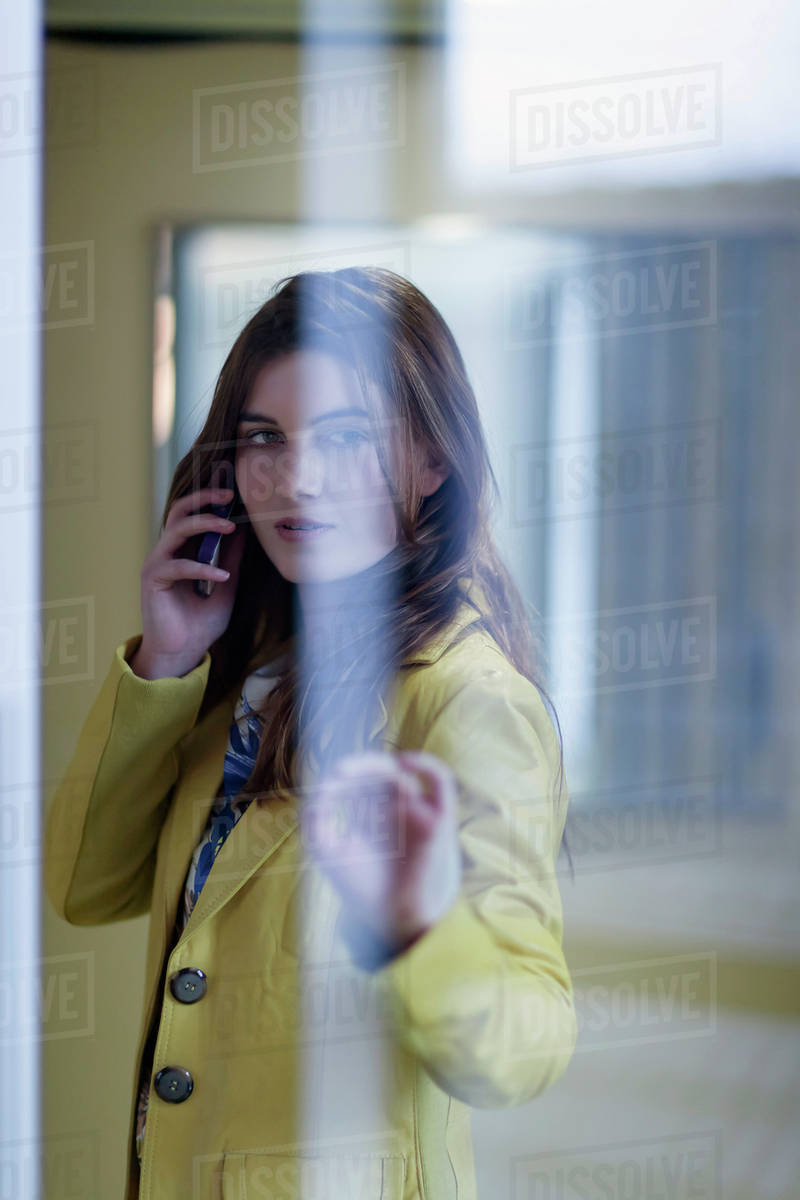 Woman behind glass door and talking on cell phone - Royalty-free Stock ...
