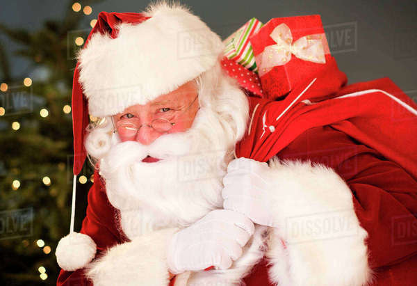 Portrait of Santa Claus carrying sack over shoulder - Royalty-free ...